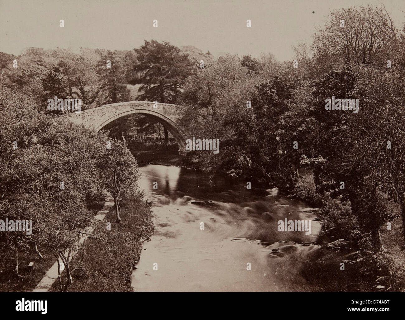 This untitled photograph captures a bridge crossing a river, showcasing ...