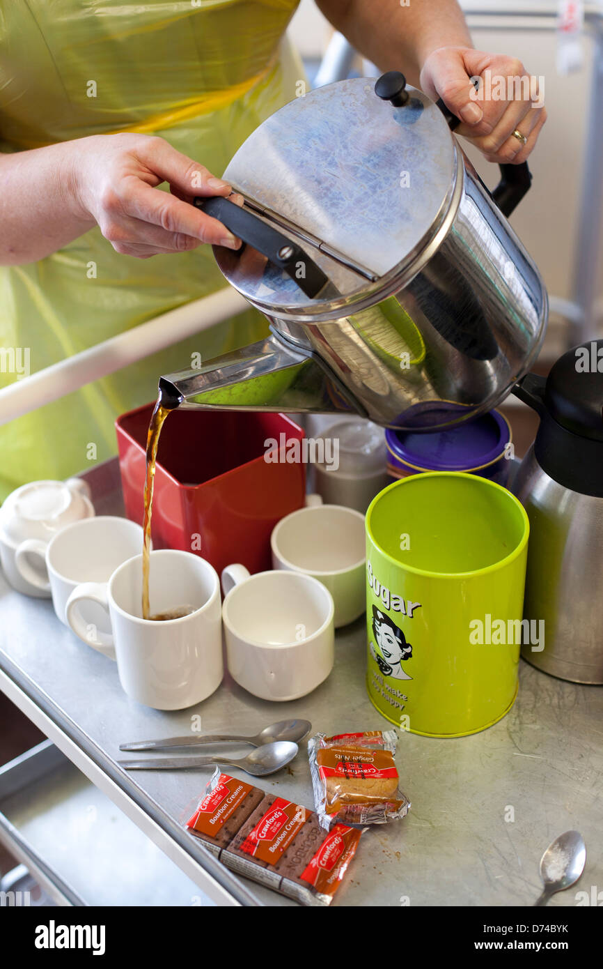 A care assistant pours a cup of tea on a trolley on a ward in ...
