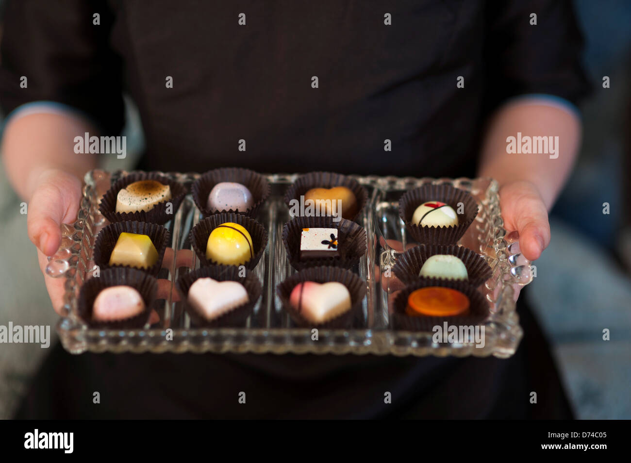Young girl carrying a glass tray of fancy candies Stock Photo - Alamy