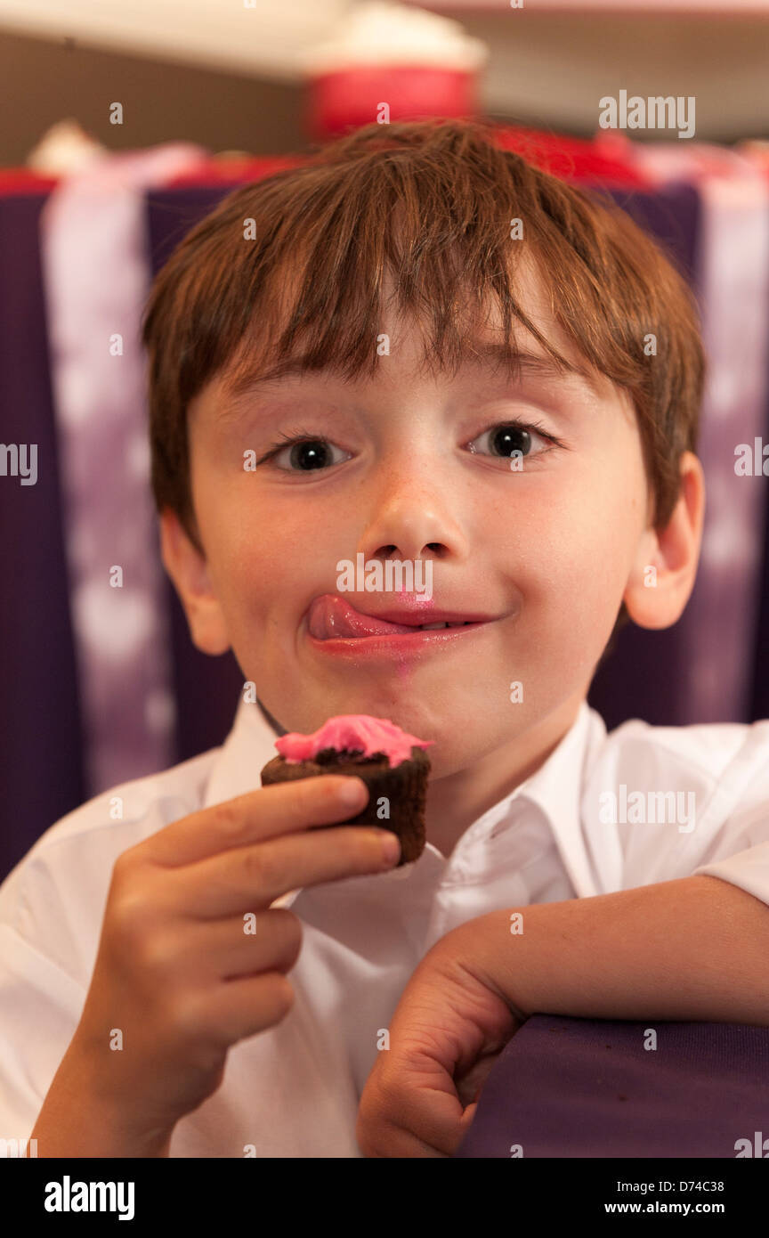Young boy licking his lips from cupcake frosting Stock Photo - Alamy