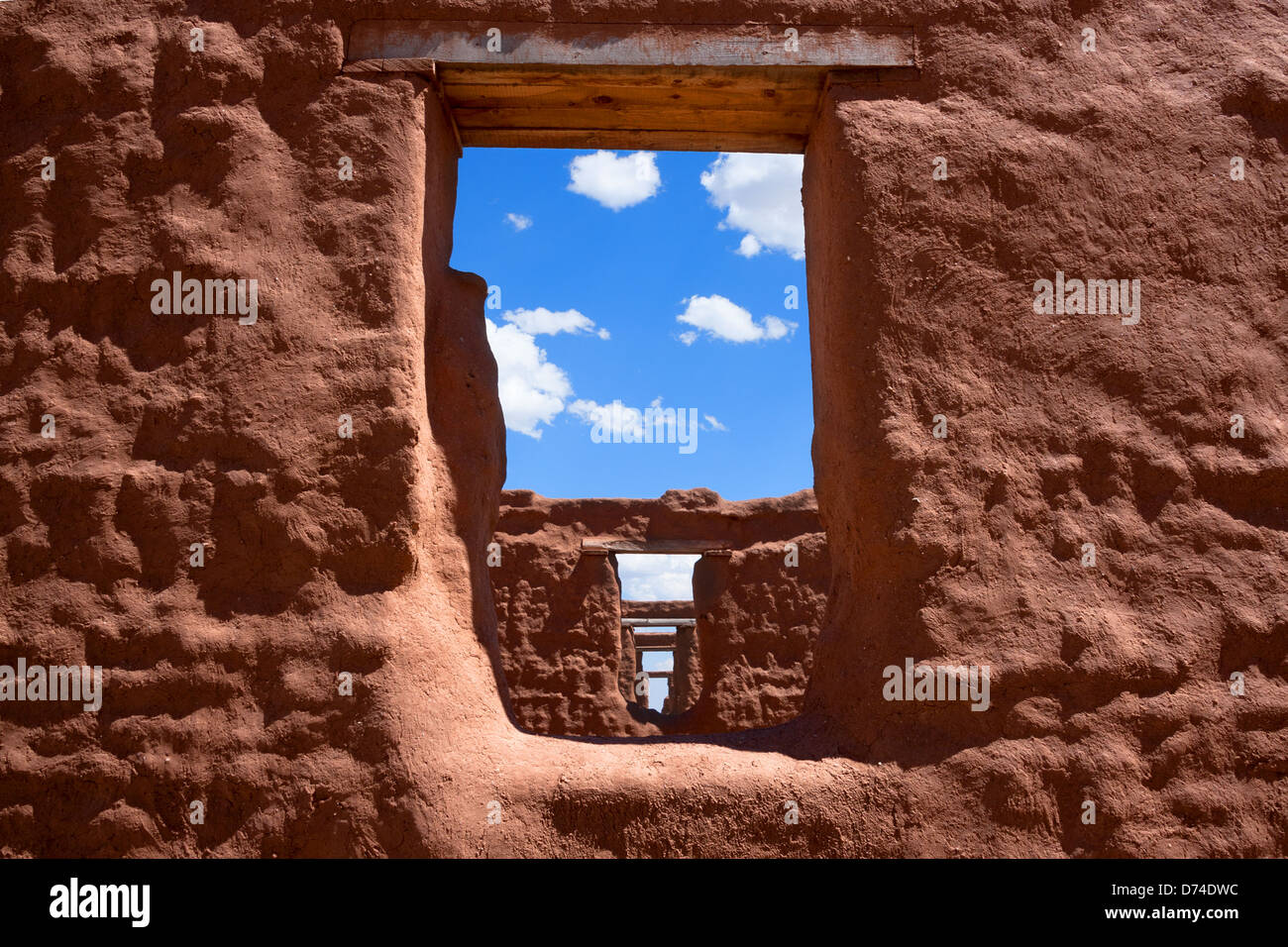 View through windows in a row of ruins of red adobe style buildings ...