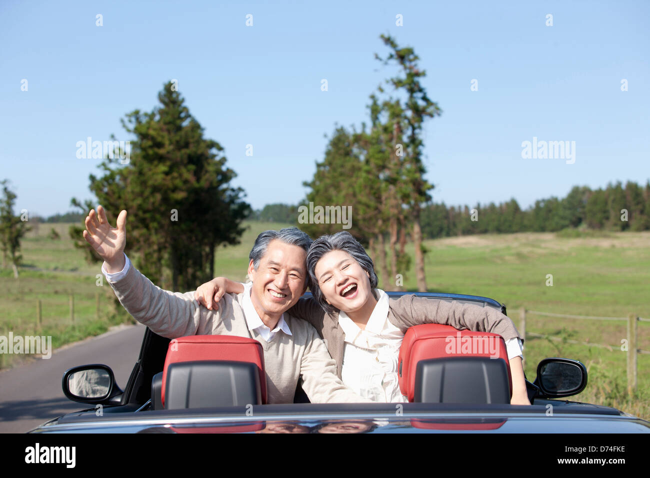 middle aged couple smiling in front seats of a car Stock Photo - Alamy