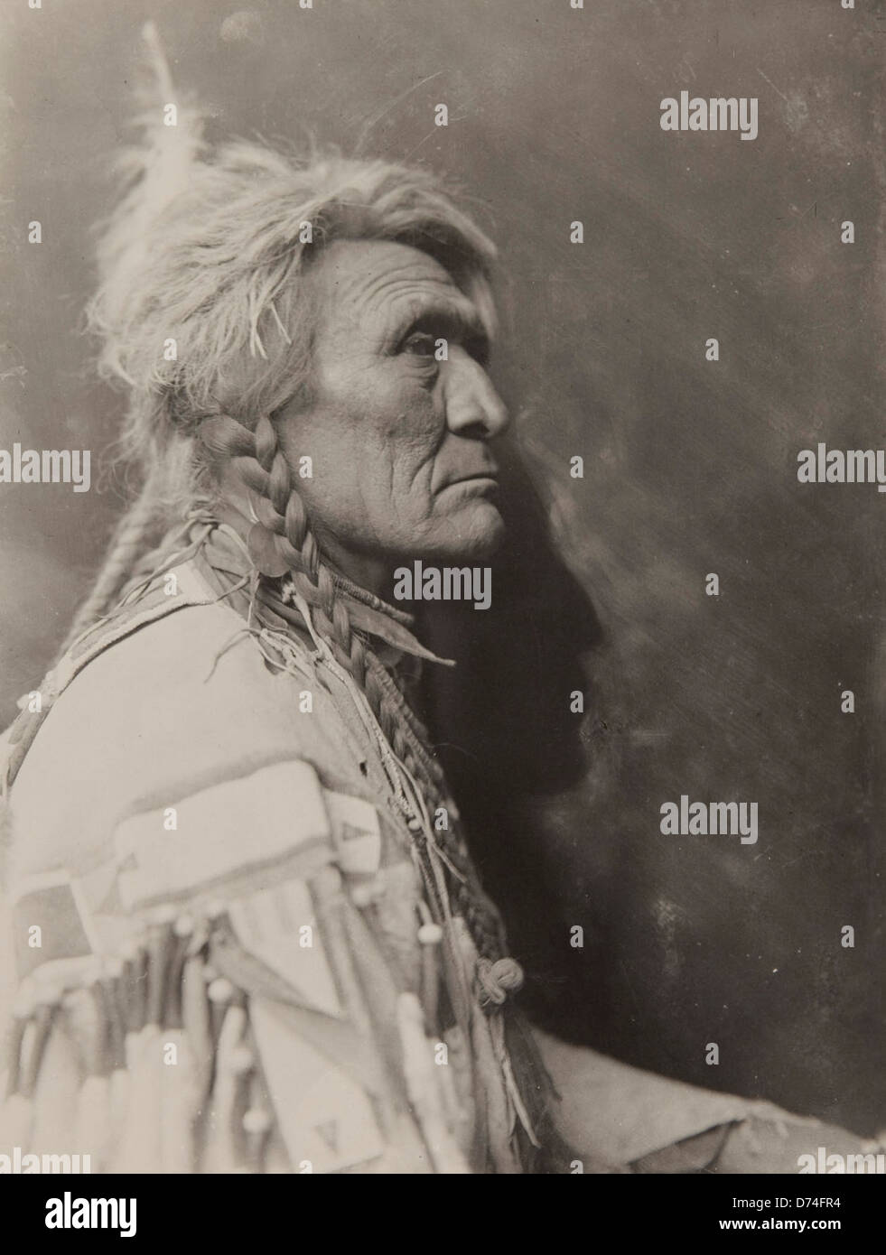 A profile portrait of an older Native American man with a braid ...