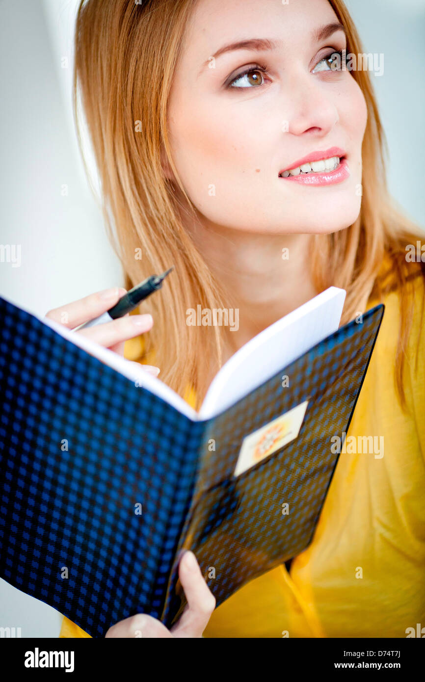 Woman writing in notebook Stock Photo - Alamy
