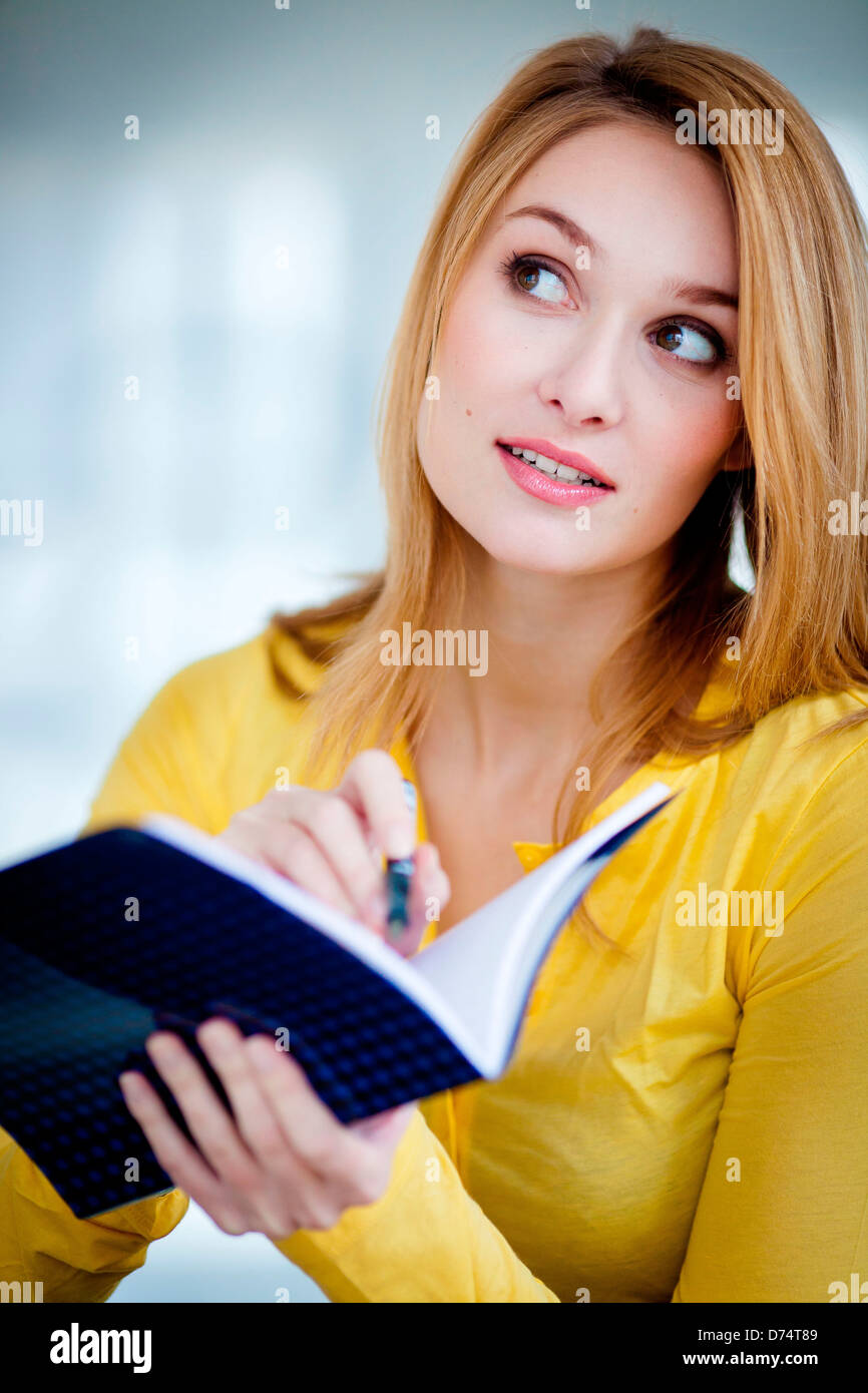 Woman writing in notebook Stock Photo - Alamy