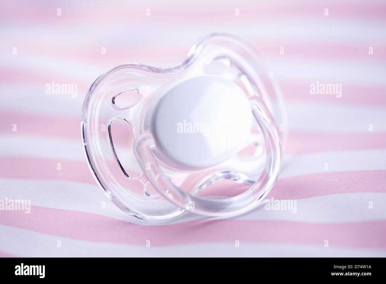 baby pacifier on striped back ground Stock Photo - Alamy