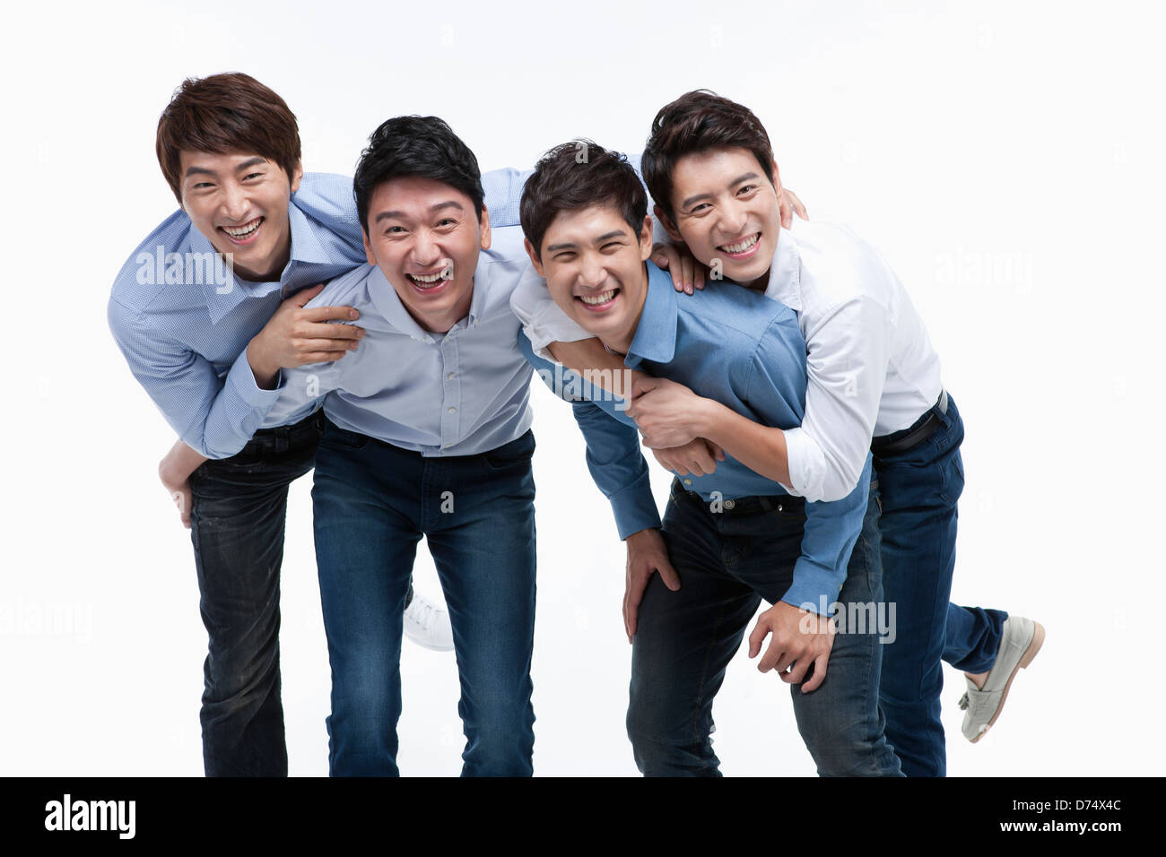 four men with shirts and jeans posing at camera Stock Photo - Alamy