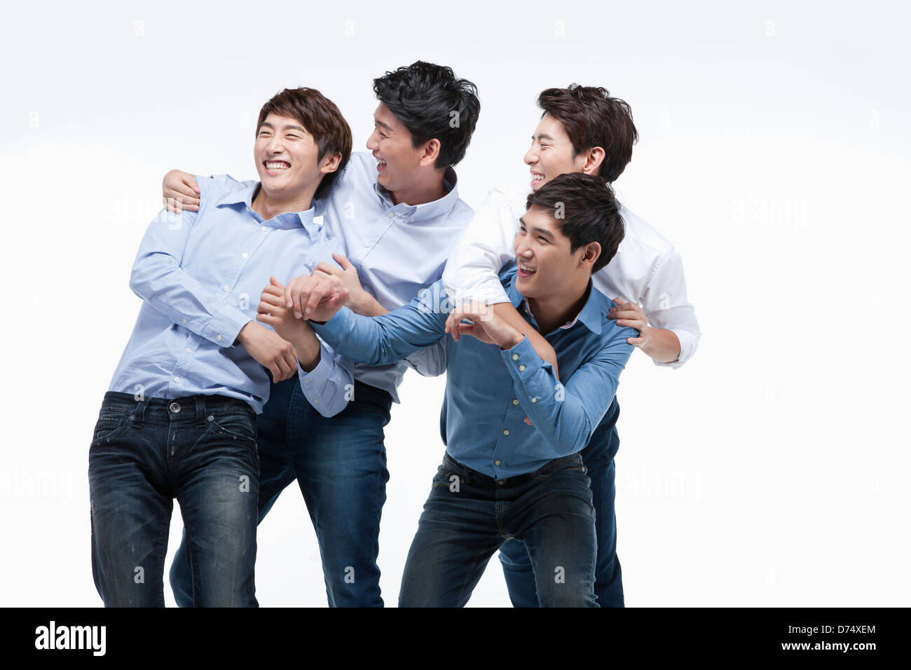 four men with shirts and jeans posing at camera Stock Photo - Alamy