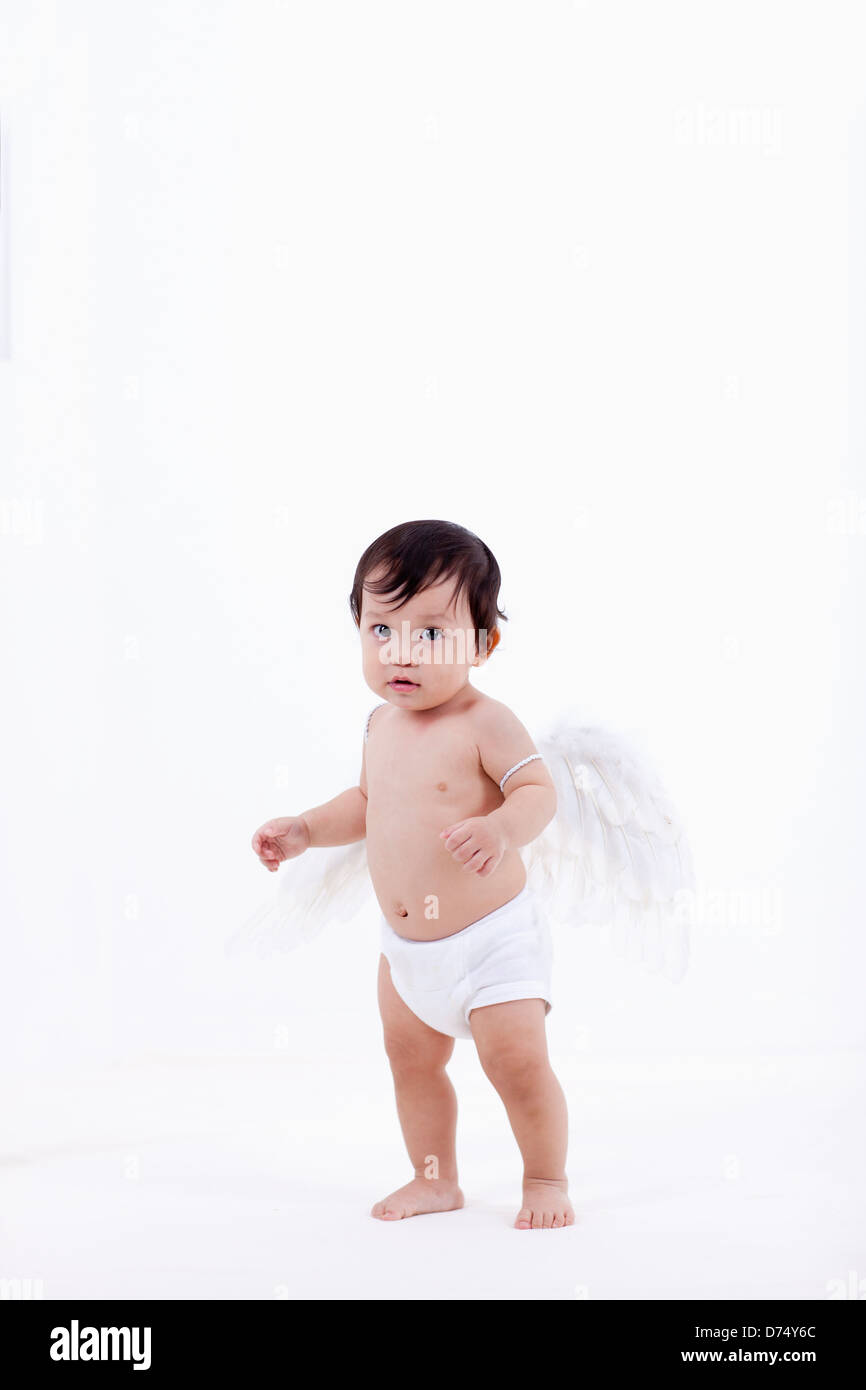 a baby standing with angel wings in the back Stock Photo - Alamy