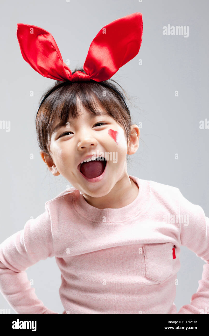 a girl with a big ribbon hair band smiling Stock Photo - Alamy