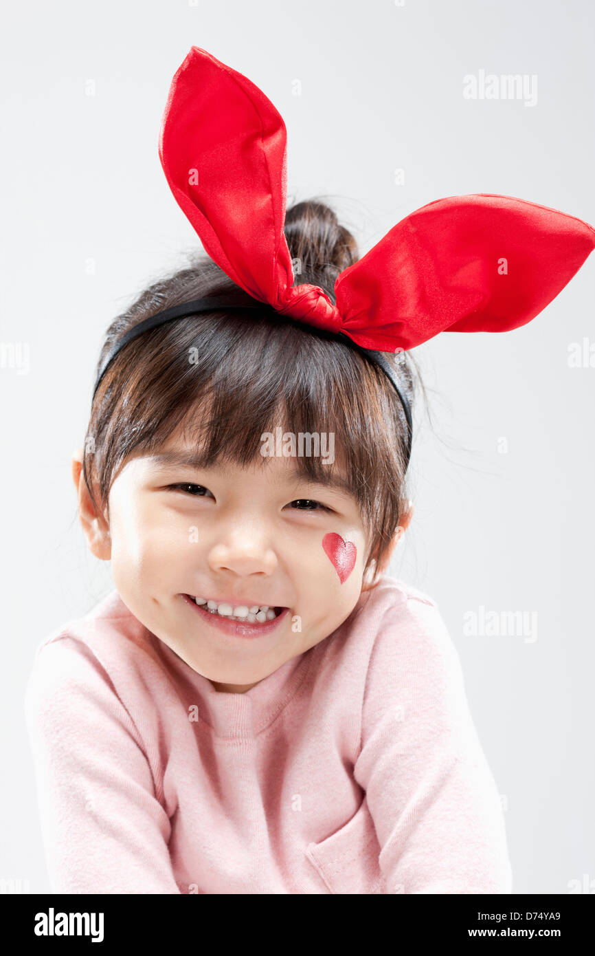a girl with a big ribbon hair band smiling Stock Photo - Alamy