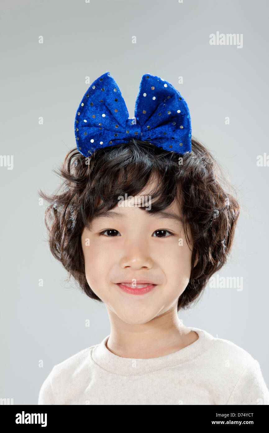 a girl with a blue ribbon hair band smiling Stock Photo - Alamy
