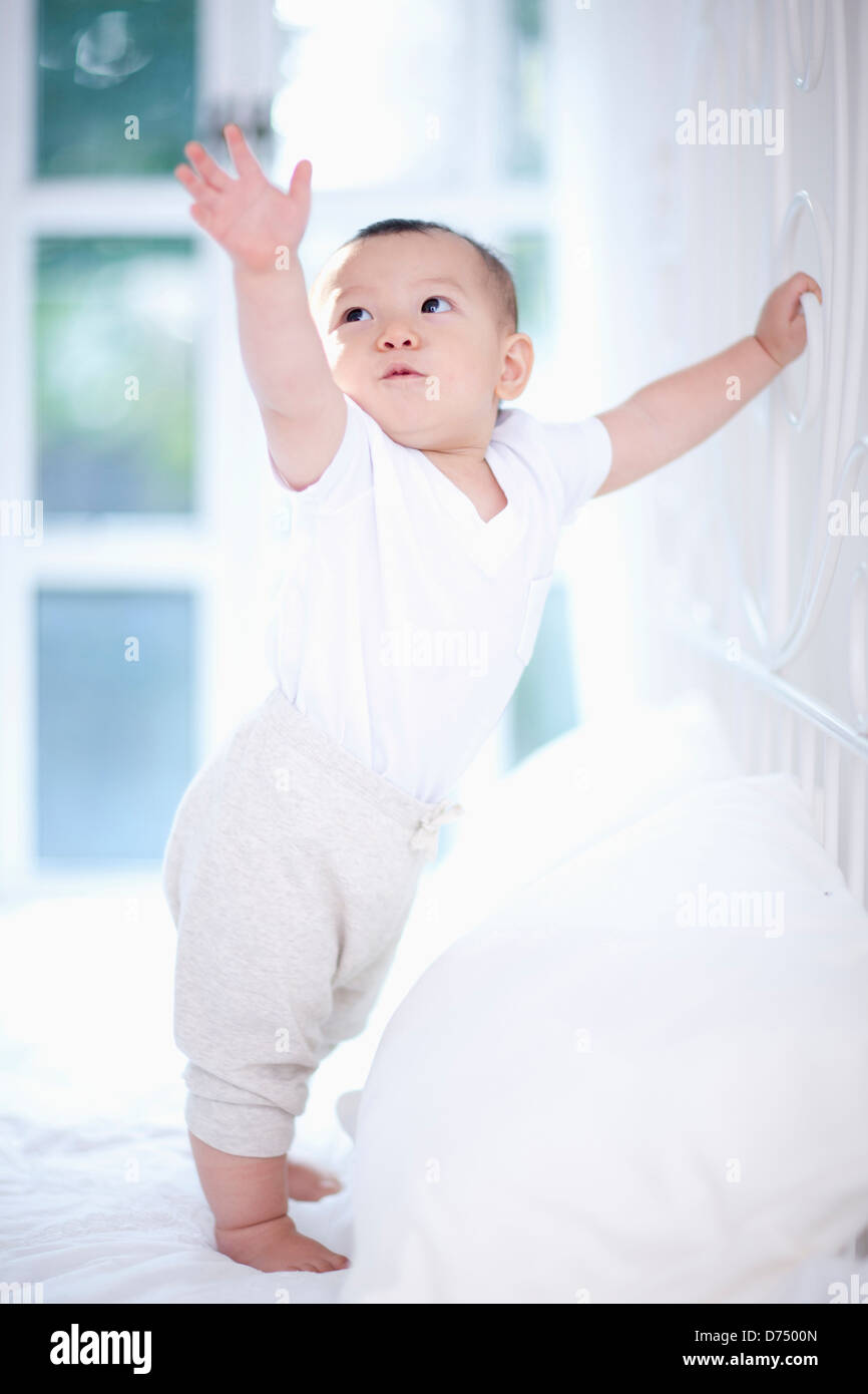a baby trying to stand up Stock Photo - Alamy