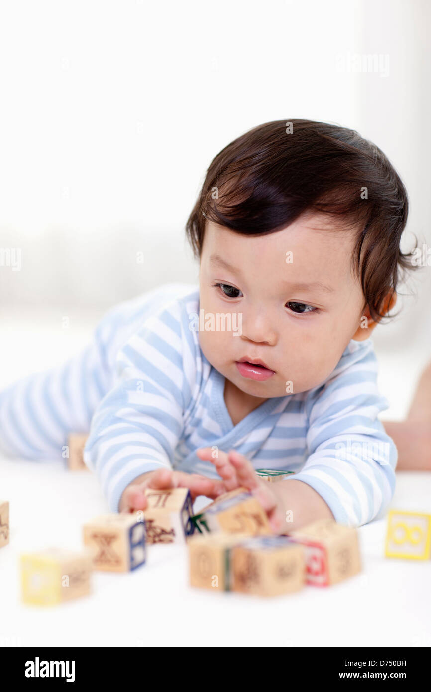 a baby playing with blocks on the floor Stock Photo - Alamy