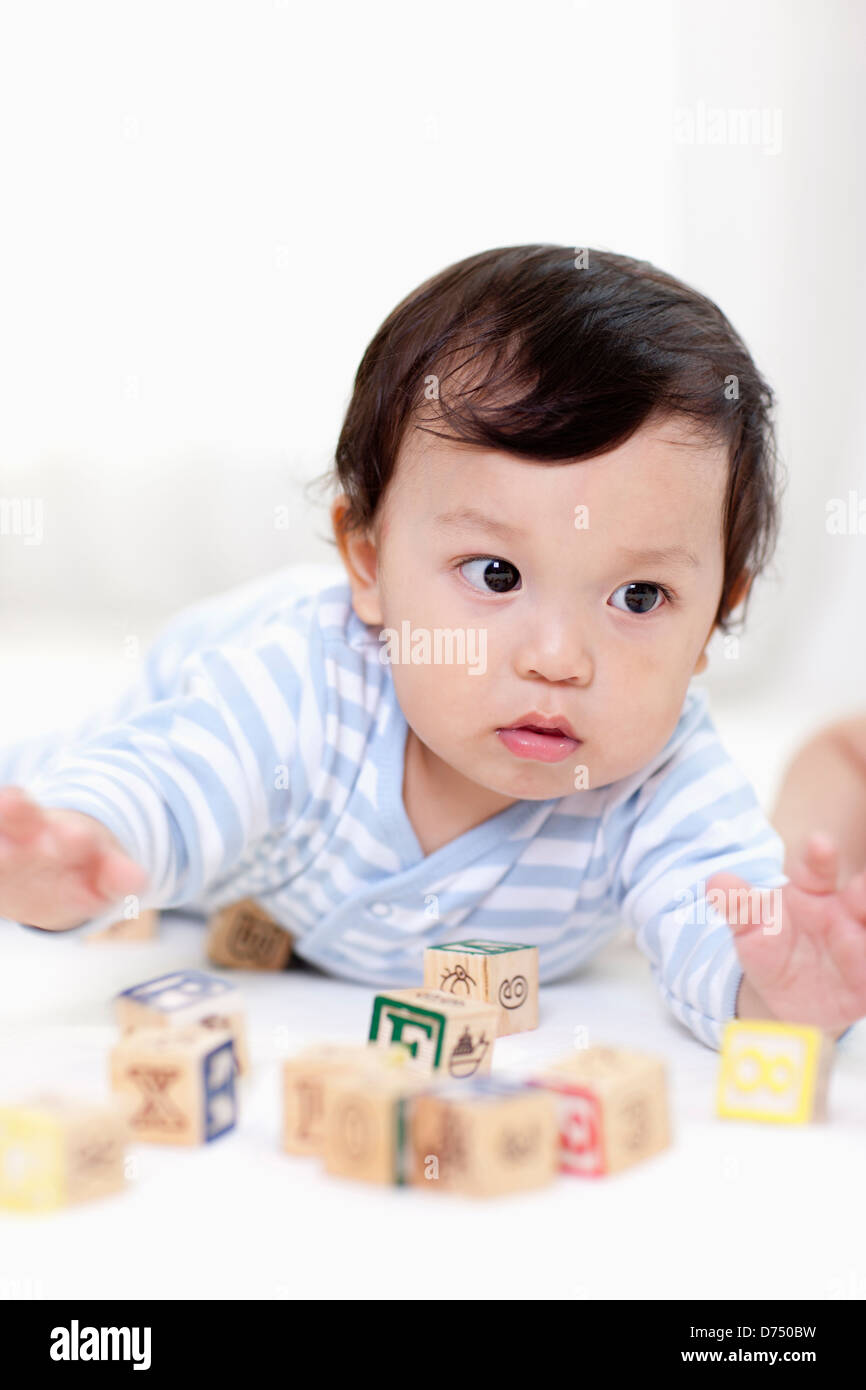 a baby playing with blocks on the floor Stock Photo - Alamy
