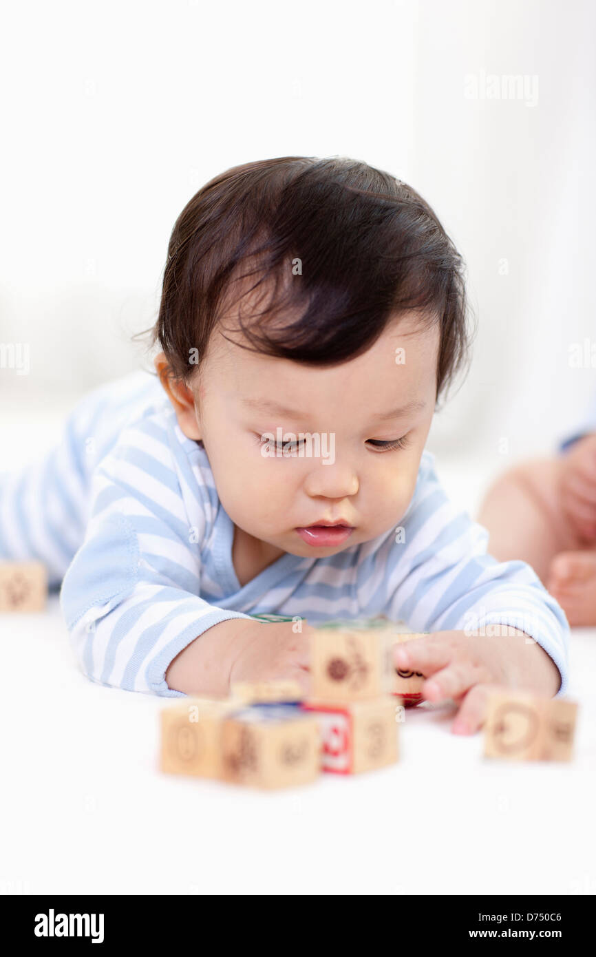 a baby playing with blocks on the floor Stock Photo - Alamy