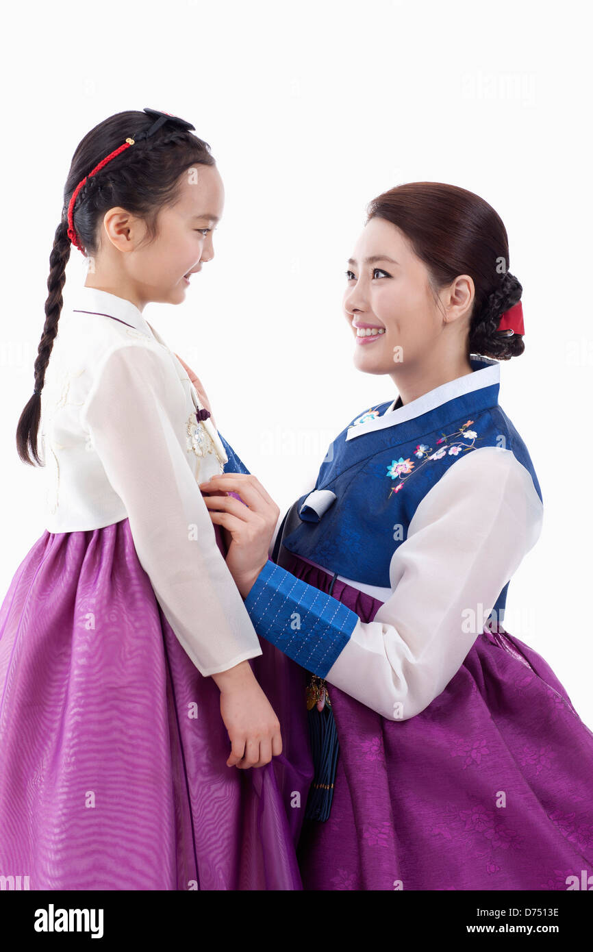 mother in Korean traditional costume fixing daughter's costume Stock ...