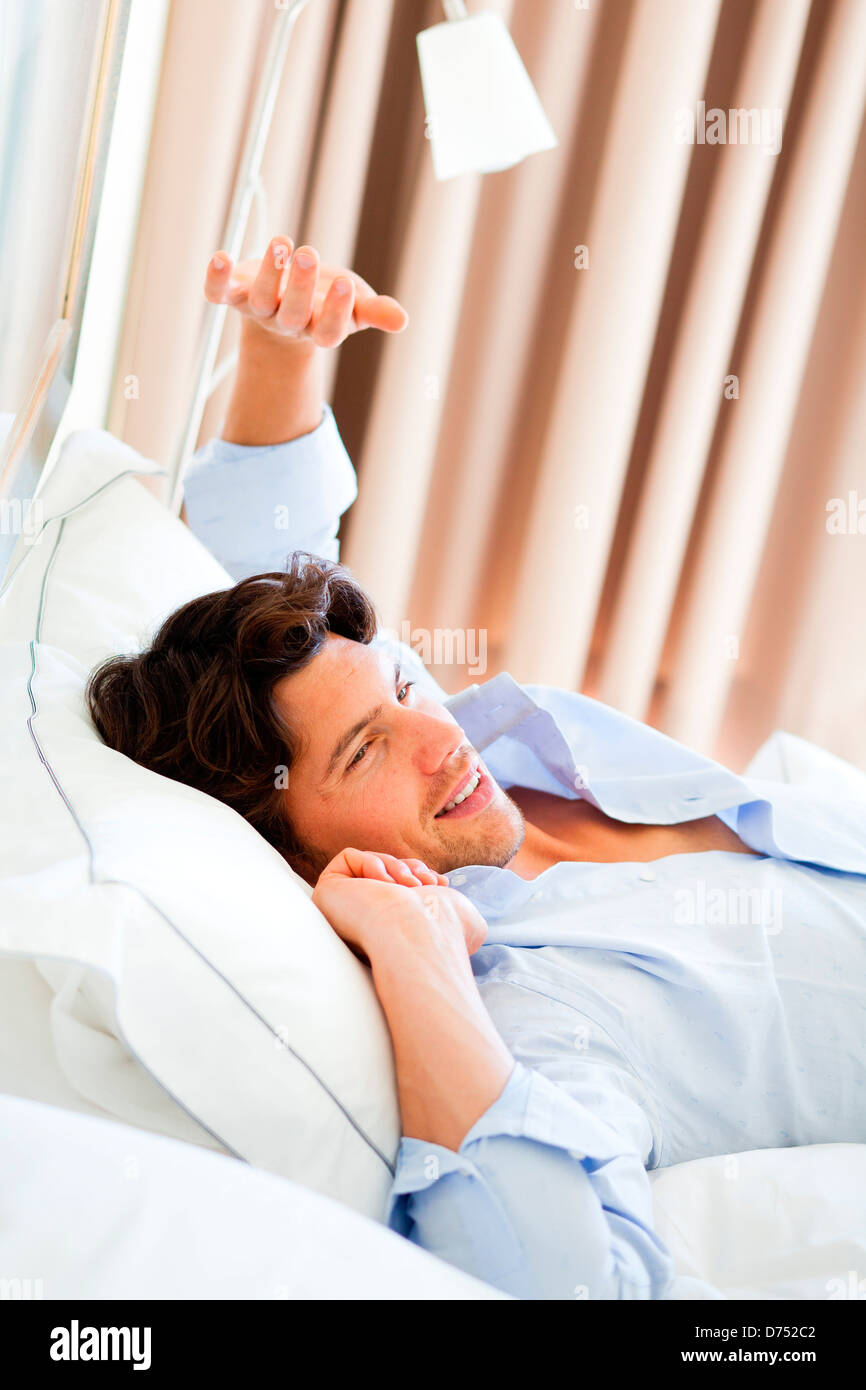 Man waking up and stretching in bed Stock Photo - Alamy