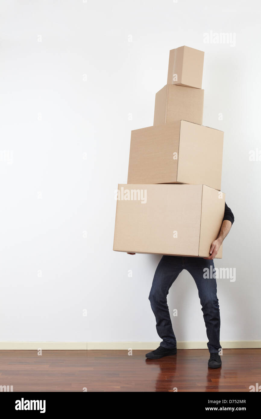 Man lifting cardboard boxes in apartment, moving day Stock Photo - Alamy