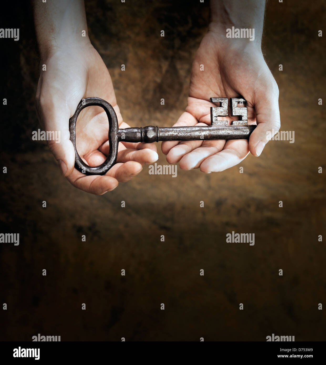Man holding a big old antique skeleton key in his hands. Very short ...