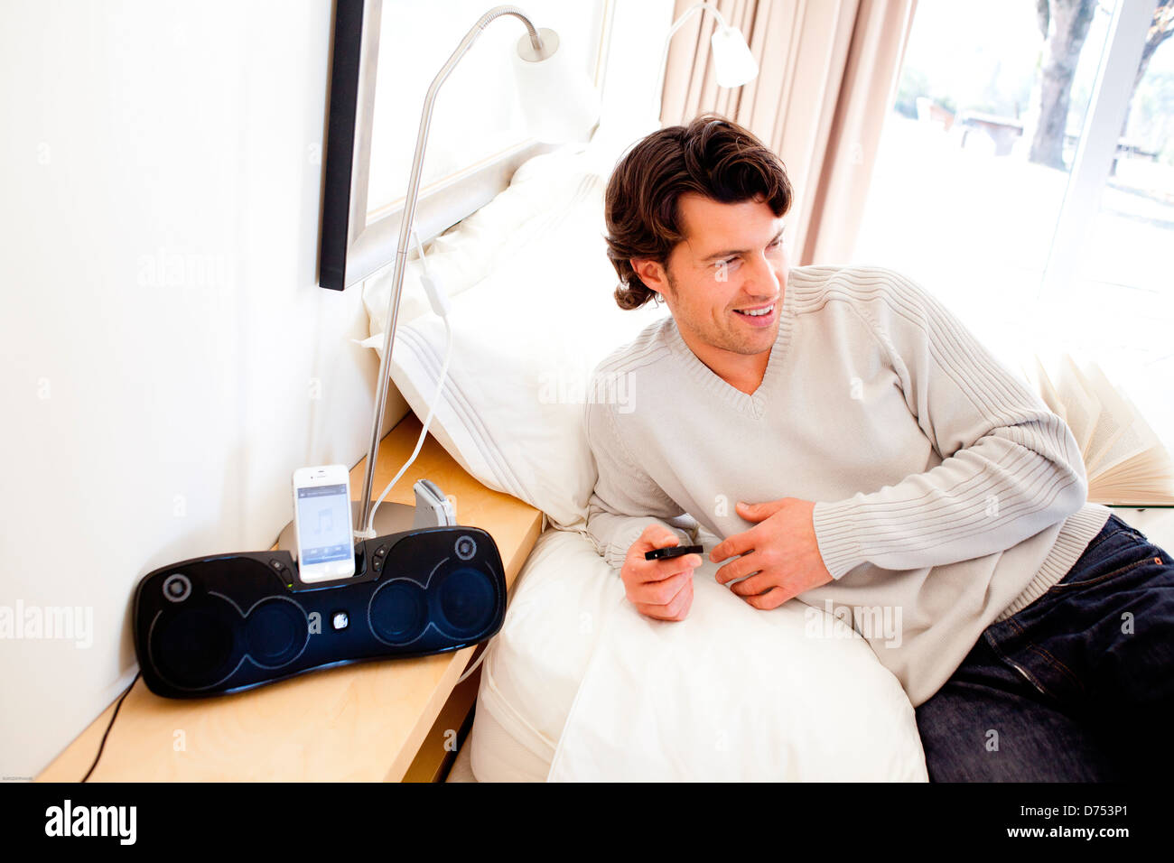 Man listening music with a mp3 player docking station Stock Photo - Alamy