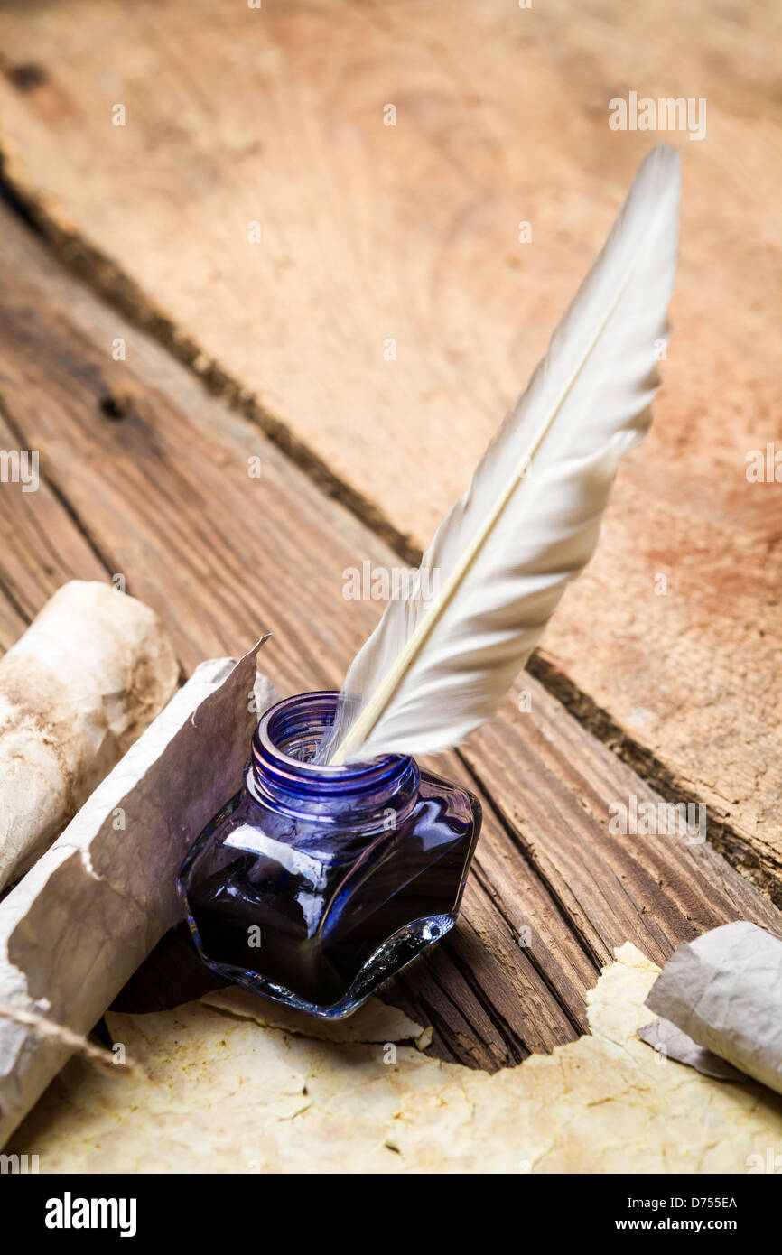 Blue ink with feather on old wooden table Stock Photo - Alamy