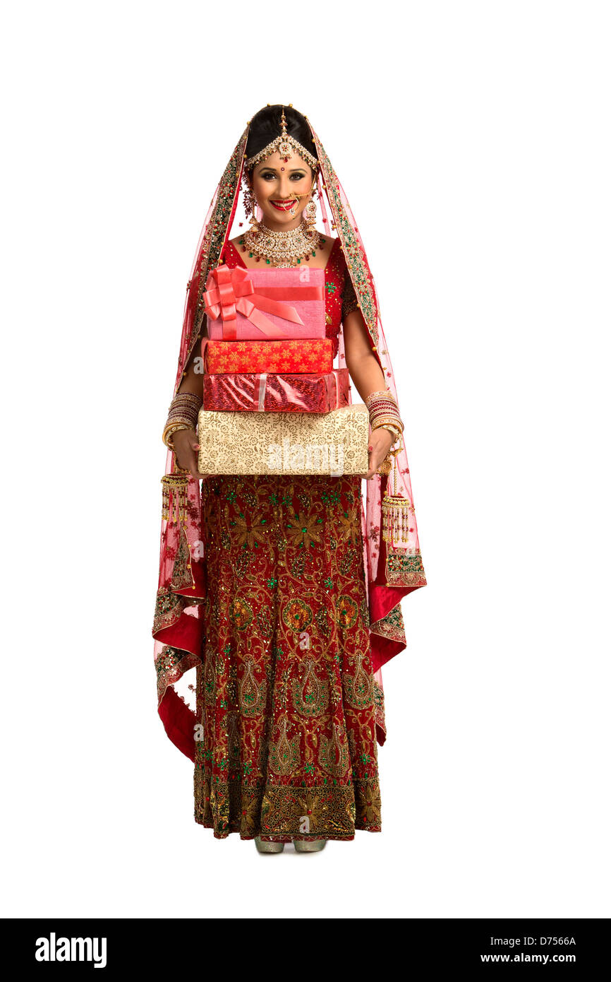 Smiling Indian bride in traditional wedding dress holding gifts Stock ...