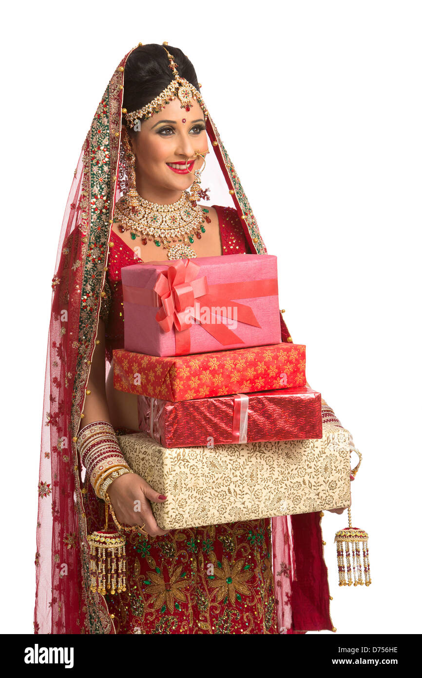 Smiling Indian bride in traditional wedding dress holding gifts Stock ...