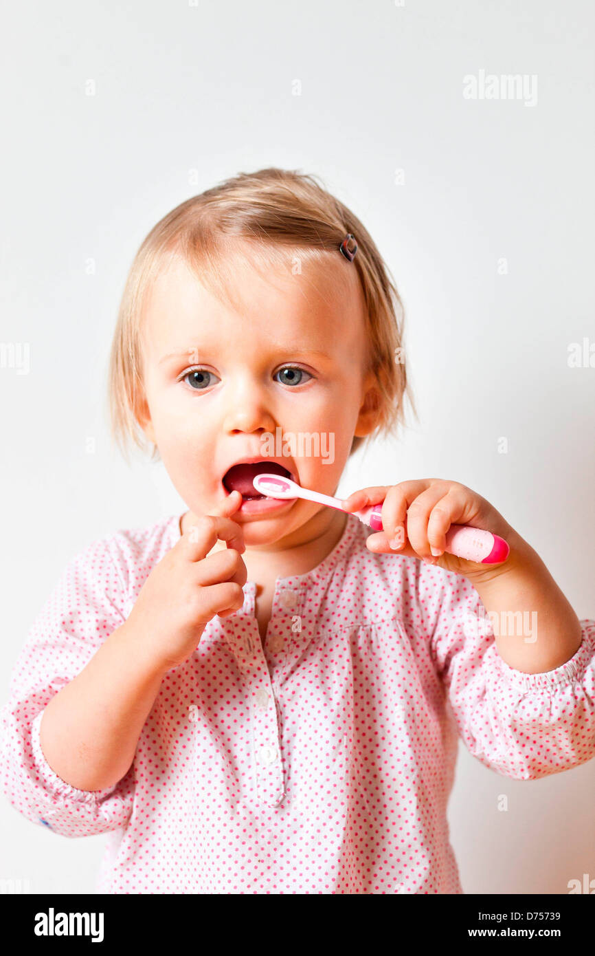 18 month old baby girl brushing her teeth Stock Photo - Alamy