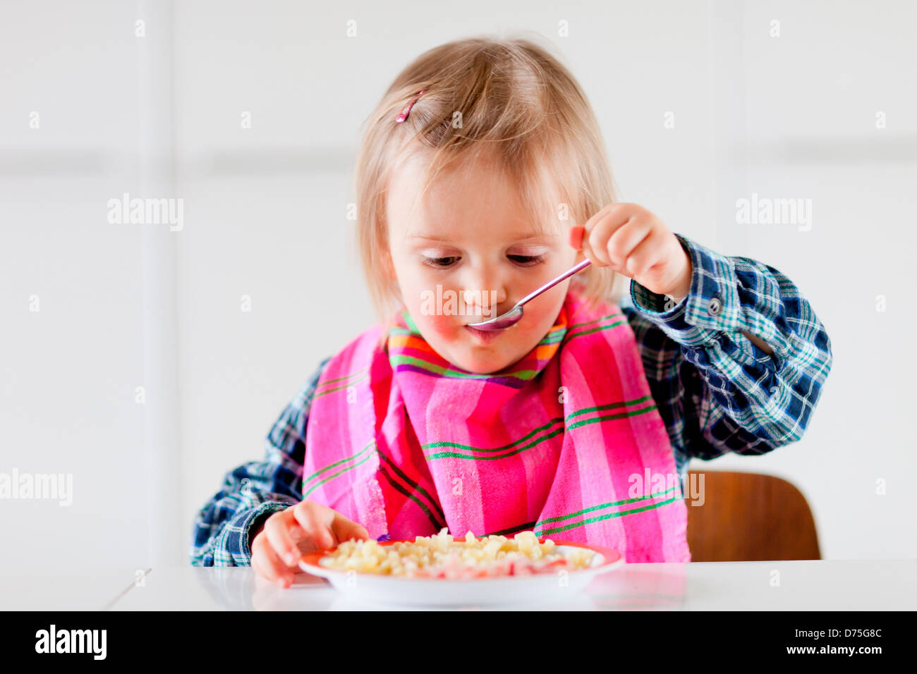 24 month old baby girl eating alone. Independence training Stock Photo ...