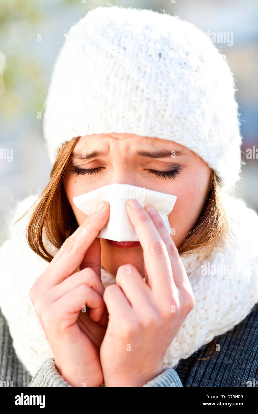 woman suffering from cold blowing her nose with a tissue Stock Photo ...
