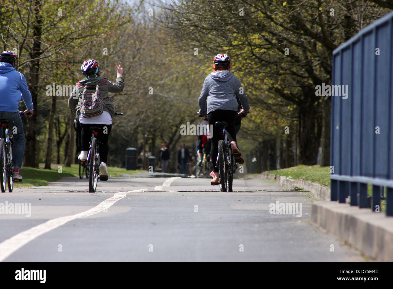 Group of young friends on their bikes on a wide cycle trail in Swansea ...
