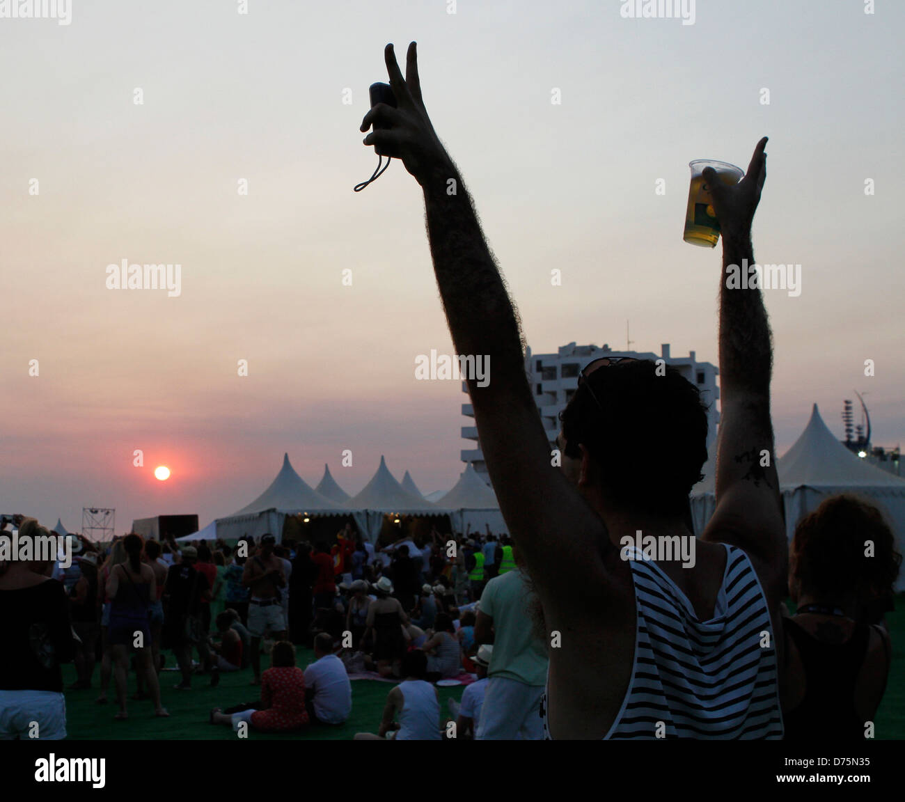 a young man raise arms on an outdoor rave party in the Spanish Balearic ...