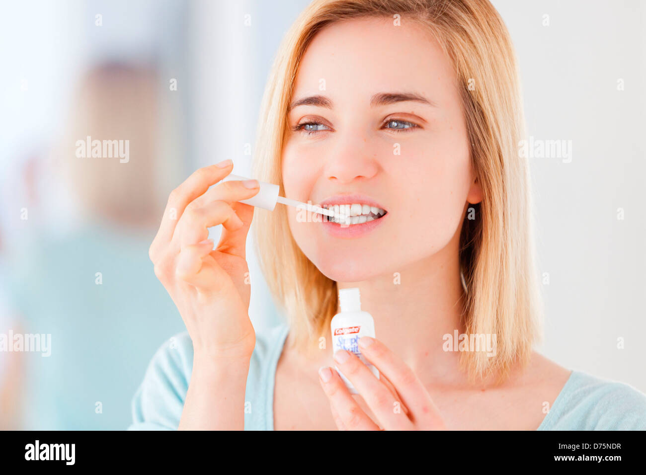 Woman applying a bleaching gel on her teeth Stock Photo - Alamy