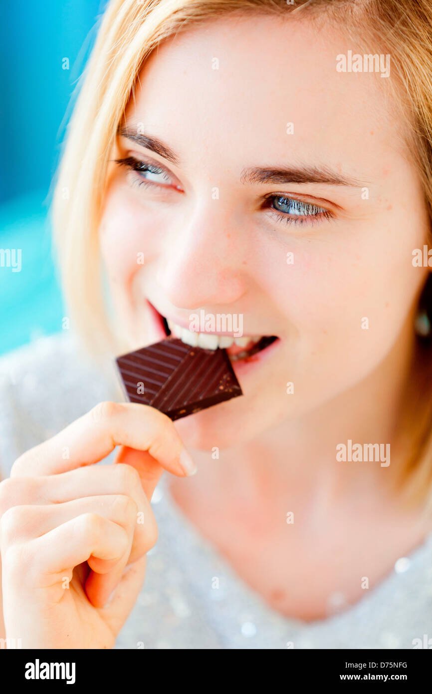 Woman eating chocolate Stock Photo - Alamy