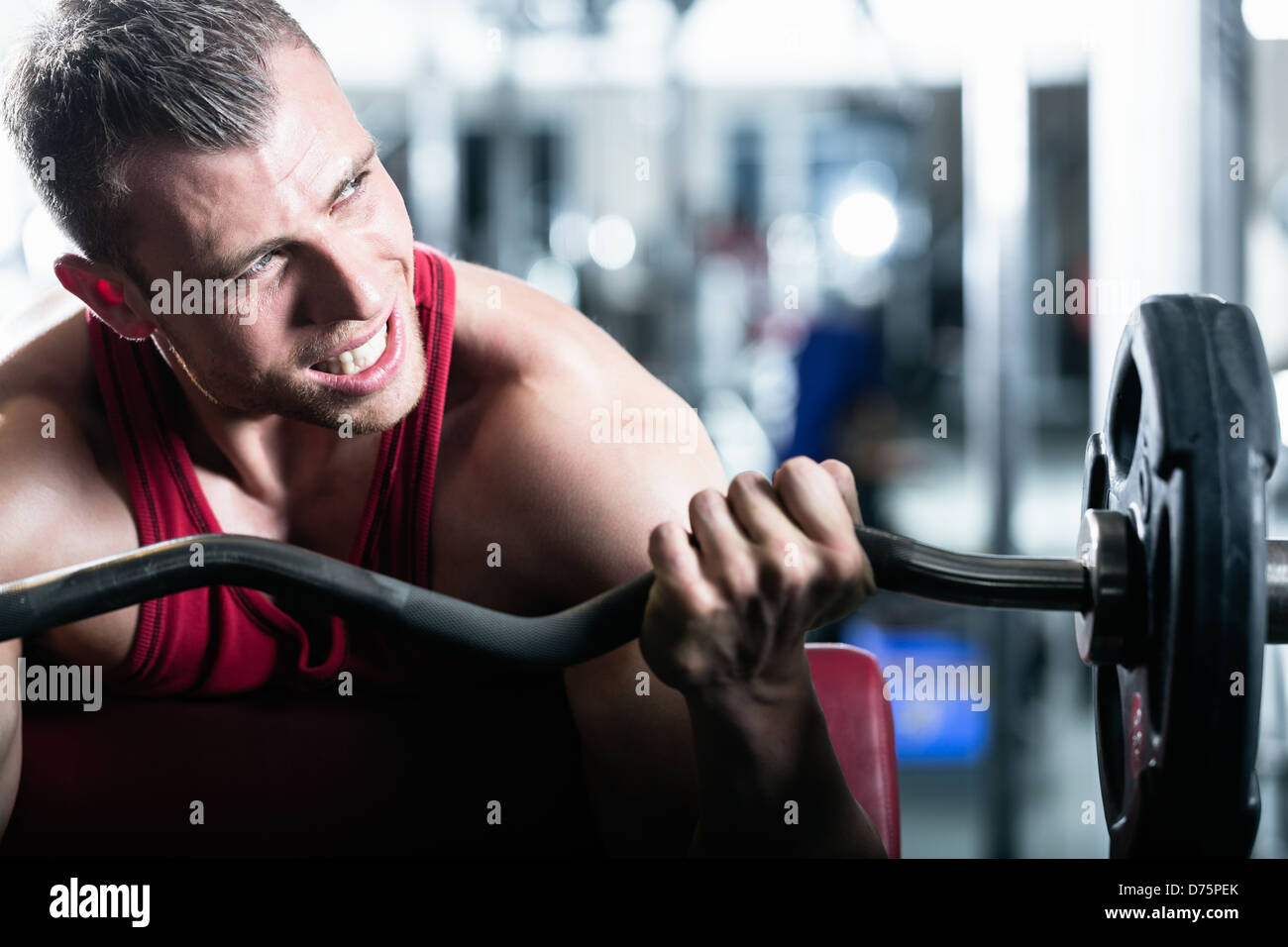 Strong man - bodybuilder with dumbbells in a gym, exercising with a ...