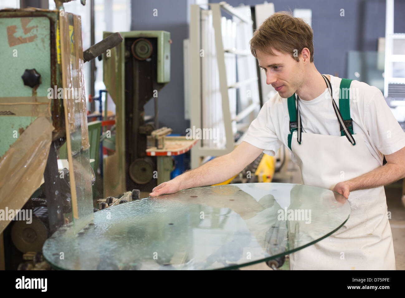 glazier deburrs a glass on grinding machine in workshop Stock Photo - Alamy