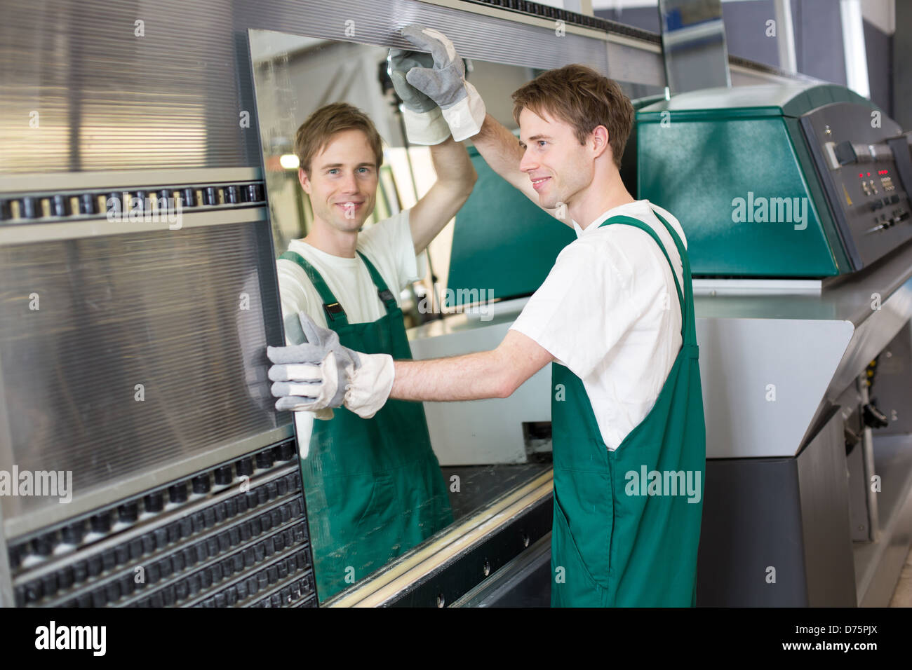 Worker in glazier's workshop putting glass in grinding machine Stock ...