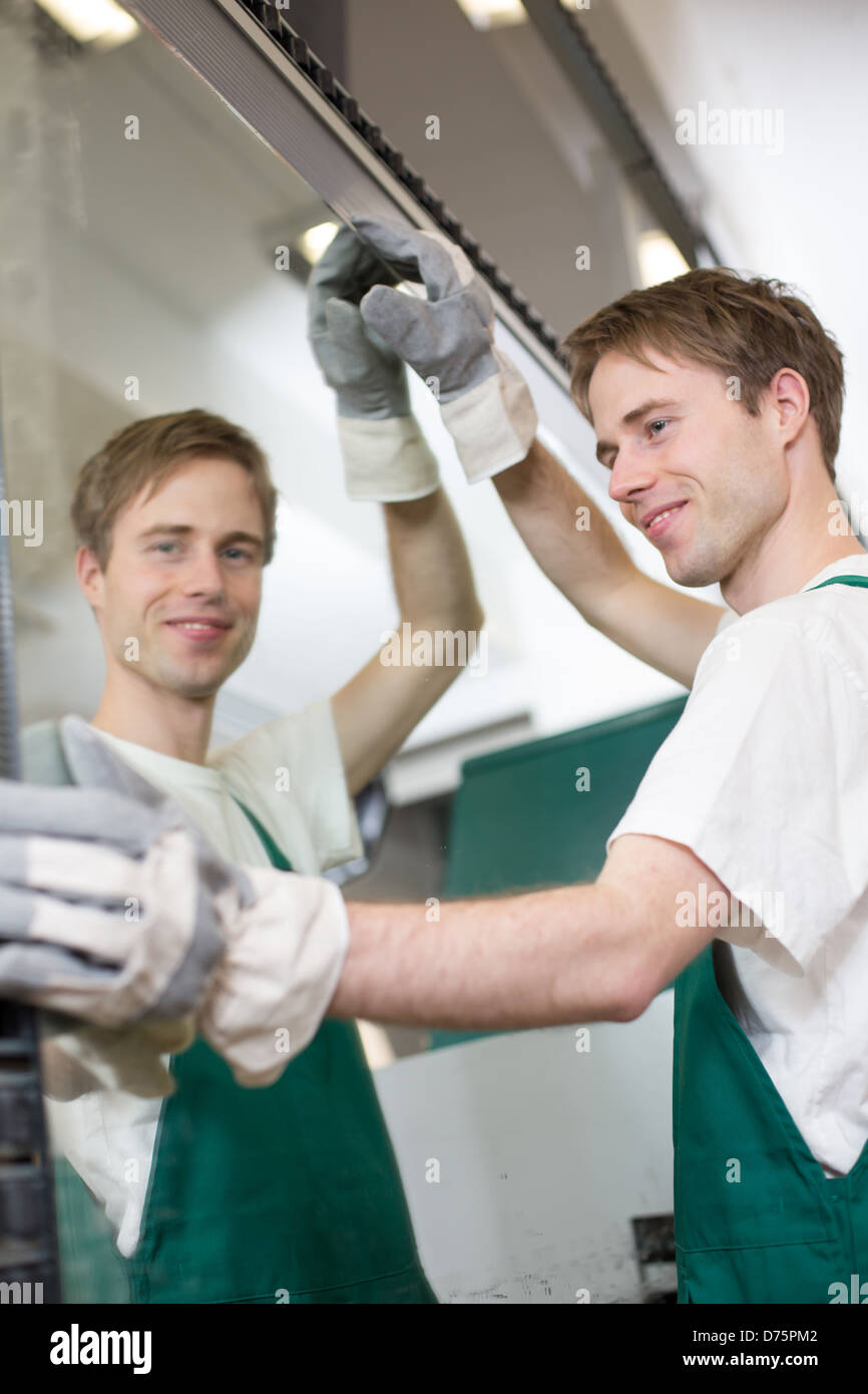 Worker in glazier's workshop putting glass in grinding machine Stock ...