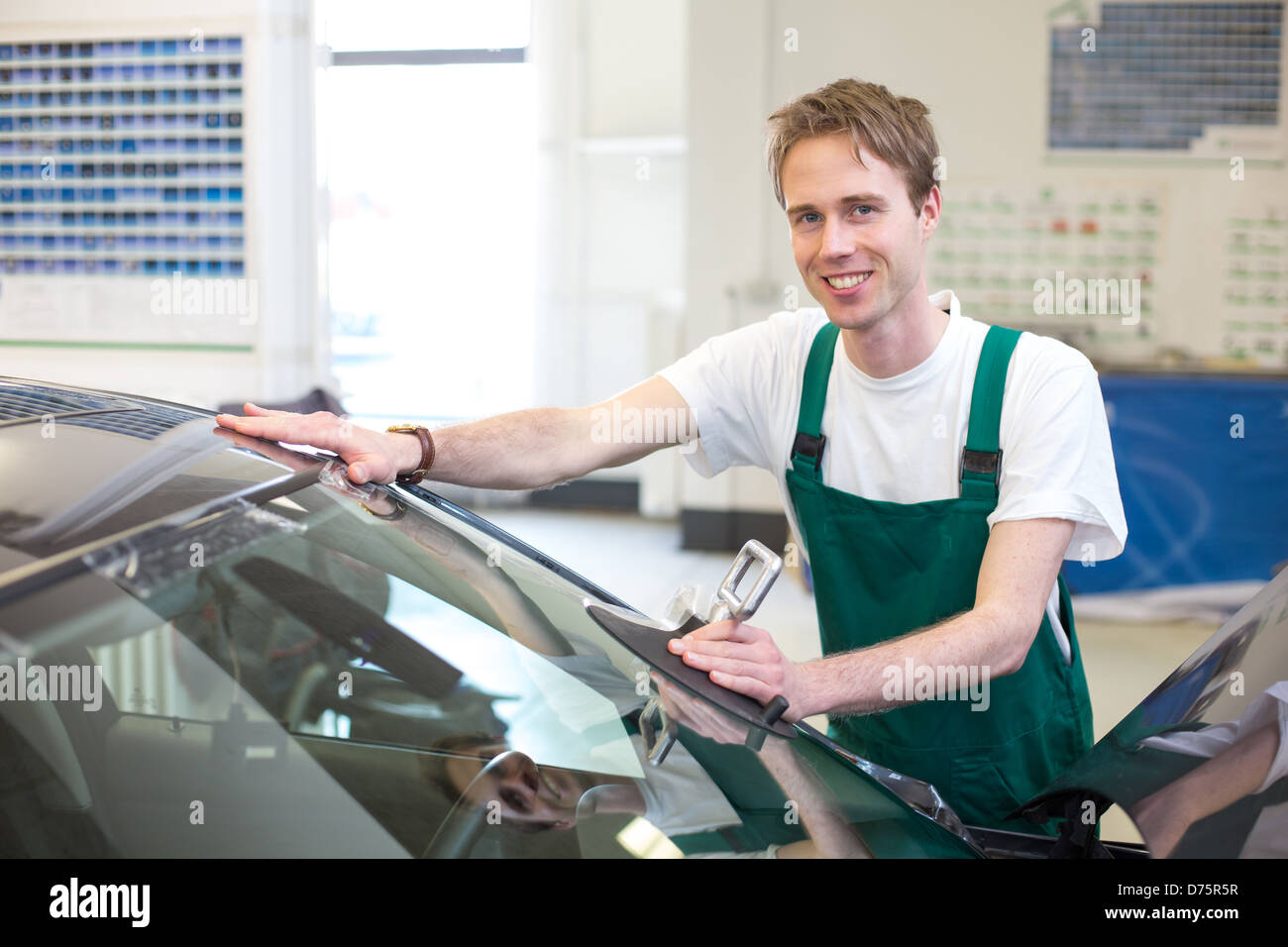 Glazier installs windscreen into car in garage Stock Photo - Alamy