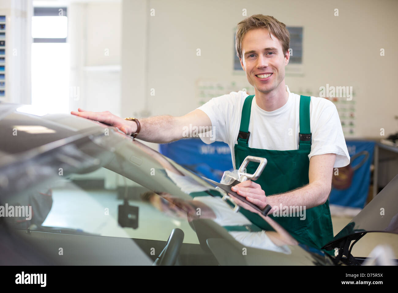 Glazier installs windscreen into car in garage Stock Photo - Alamy