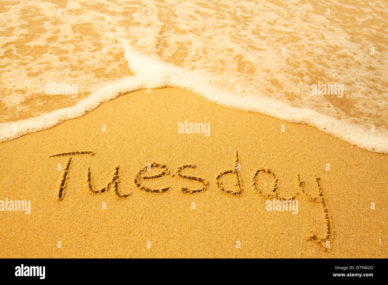 Tuesday - written in sand on beach texture Stock Photo - Alamy