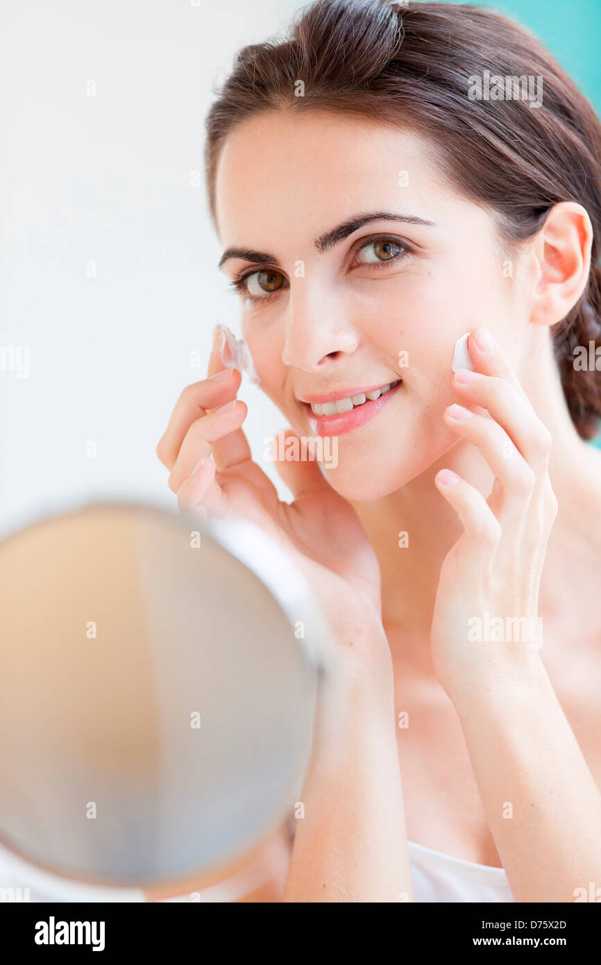 Woman 40 applying cream face bathroom hi-res stock photography and ...