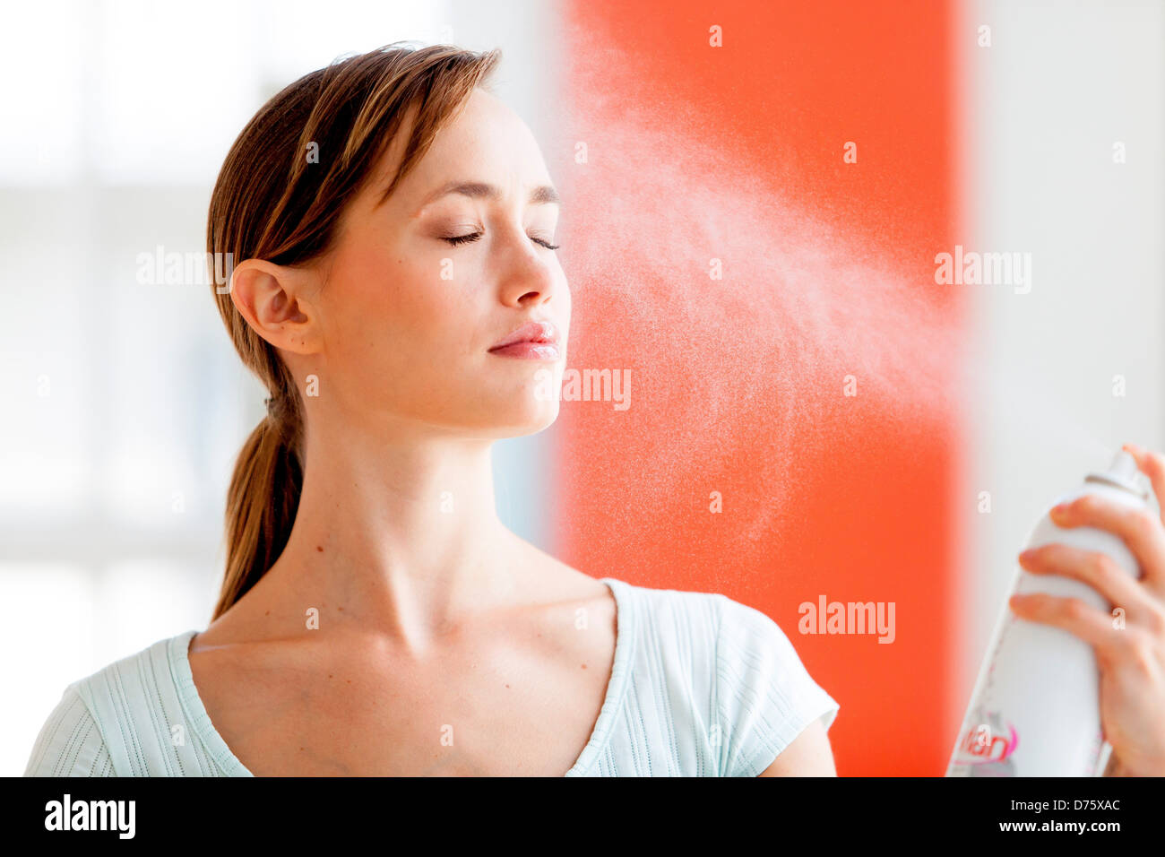 Woman spraying water on her face Stock Photo - Alamy