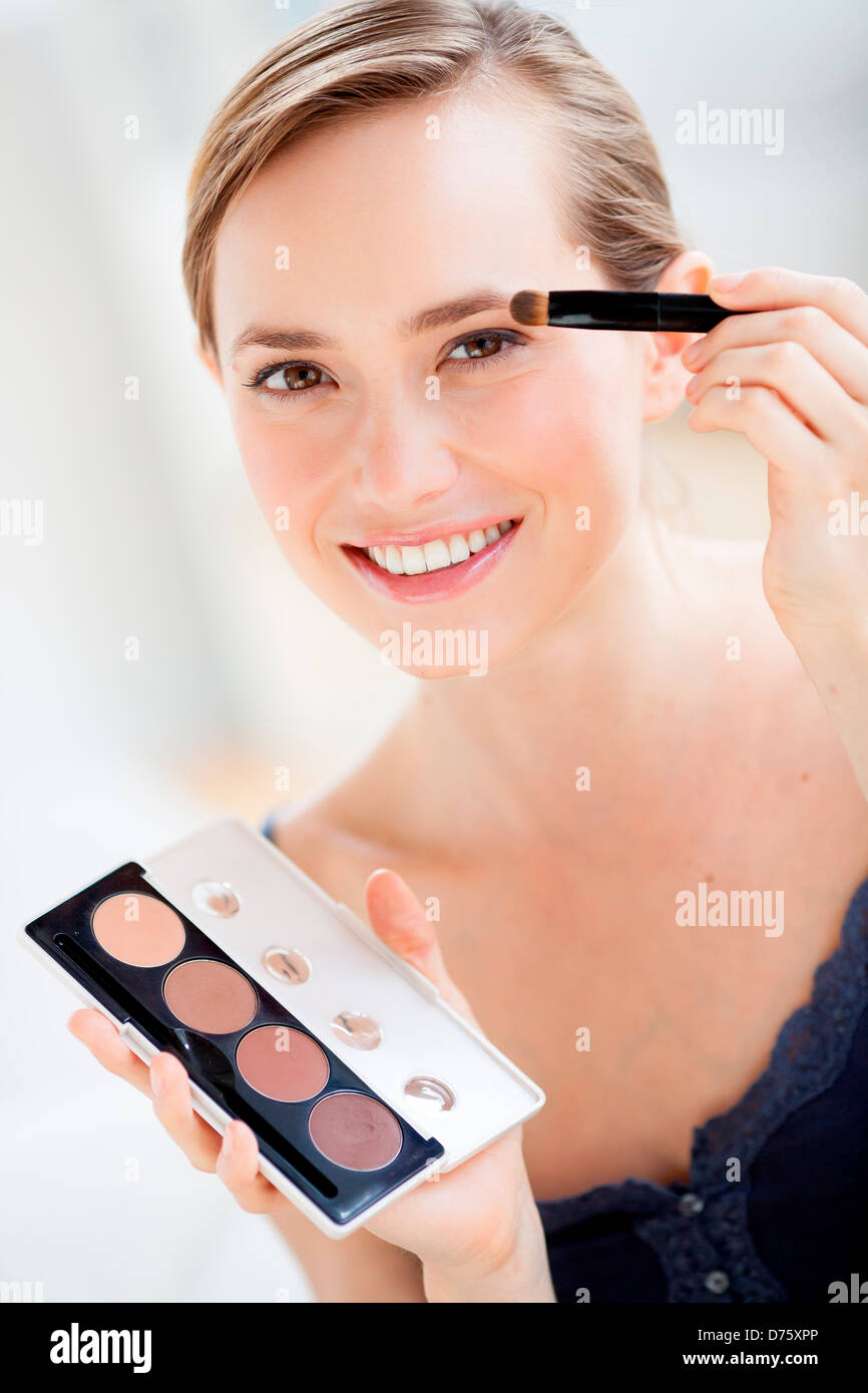 Woman applying make-up Stock Photo - Alamy