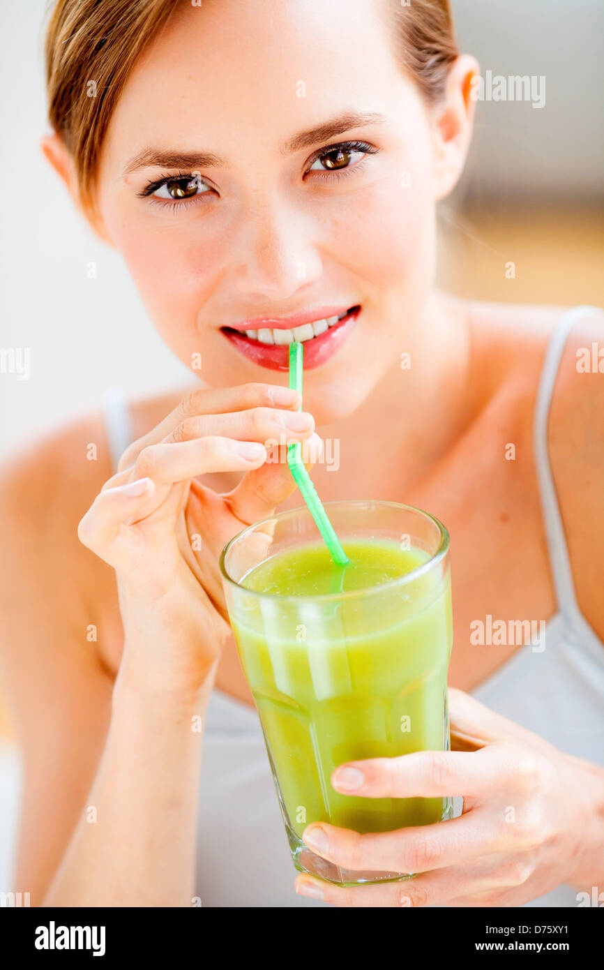 Woman drinking a smoothie (blended drink made from fruits Stock Photo ...