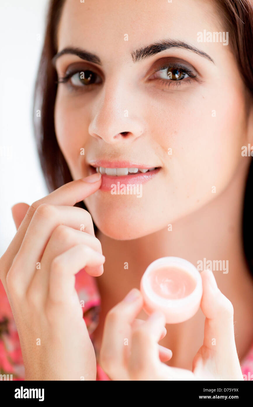 Woman applying lip balm Stock Photo - Alamy