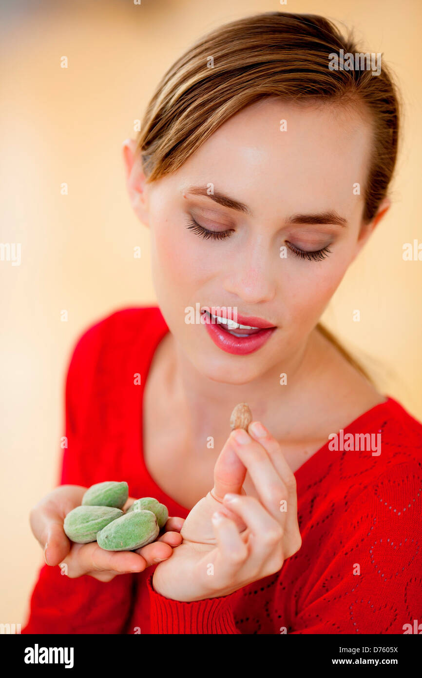 Woman eating almonds Stock Photo - Alamy