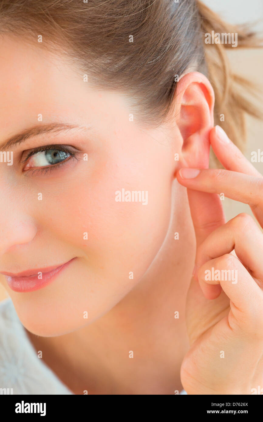 Woman massaging the ear lobe Stock Photo - Alamy