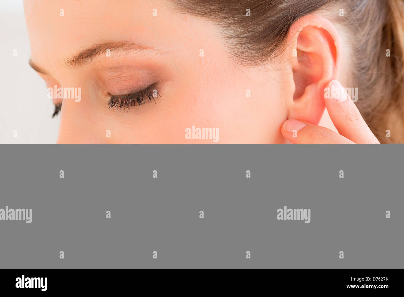 Woman massaging the ear lobe Stock Photo - Alamy